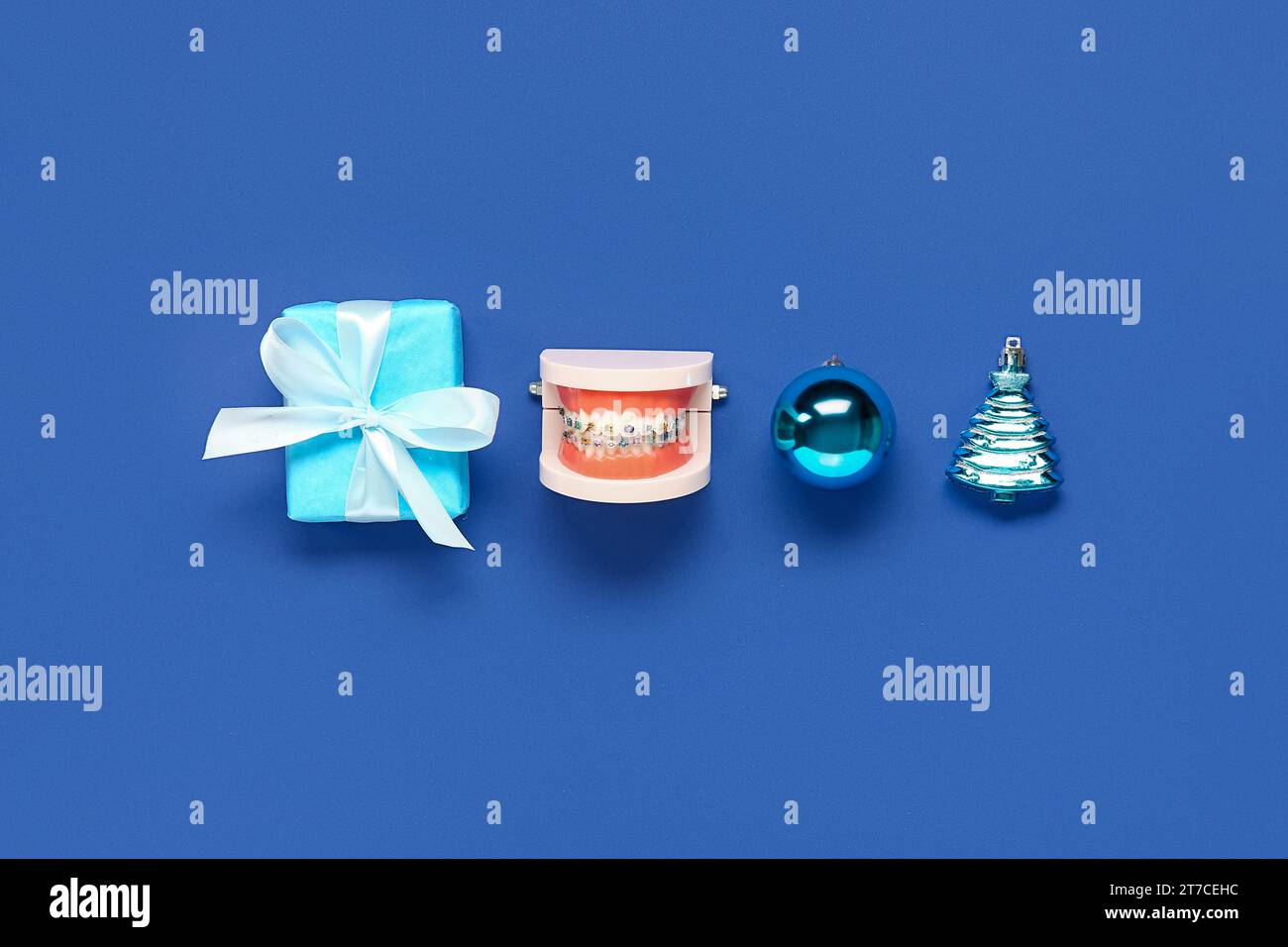 Model of jaw with dental braces, Christmas gift and decorations on blue ...