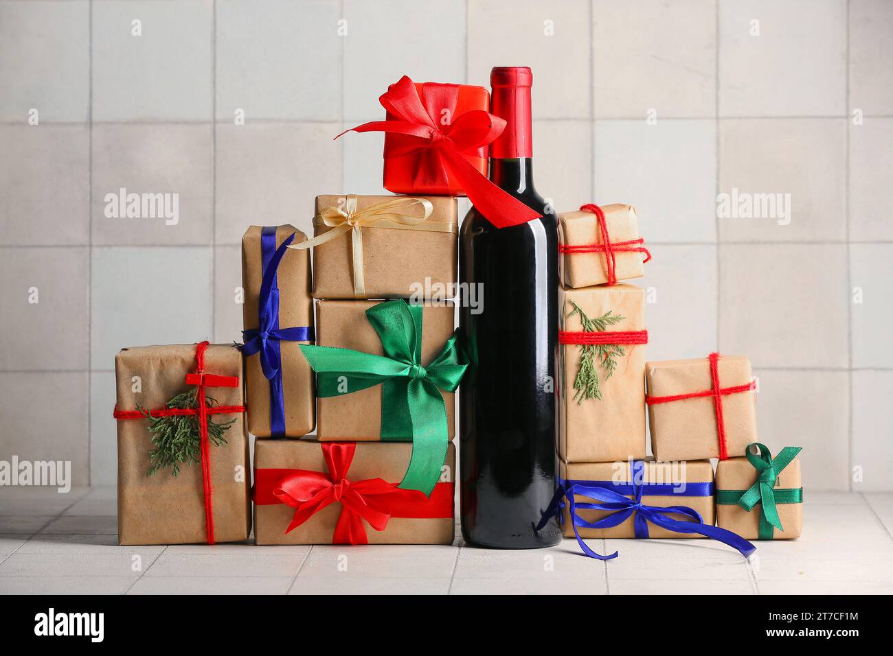 Bottle of wine and Christmas gift boxes on white tile background Stock ...