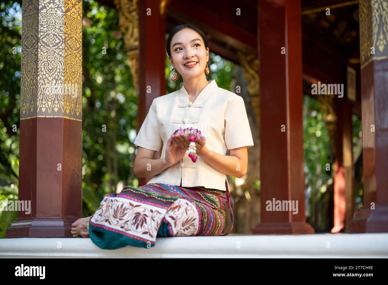 An attractive Thai-Asian woman in a beautiful traditional Thai-Northern ...