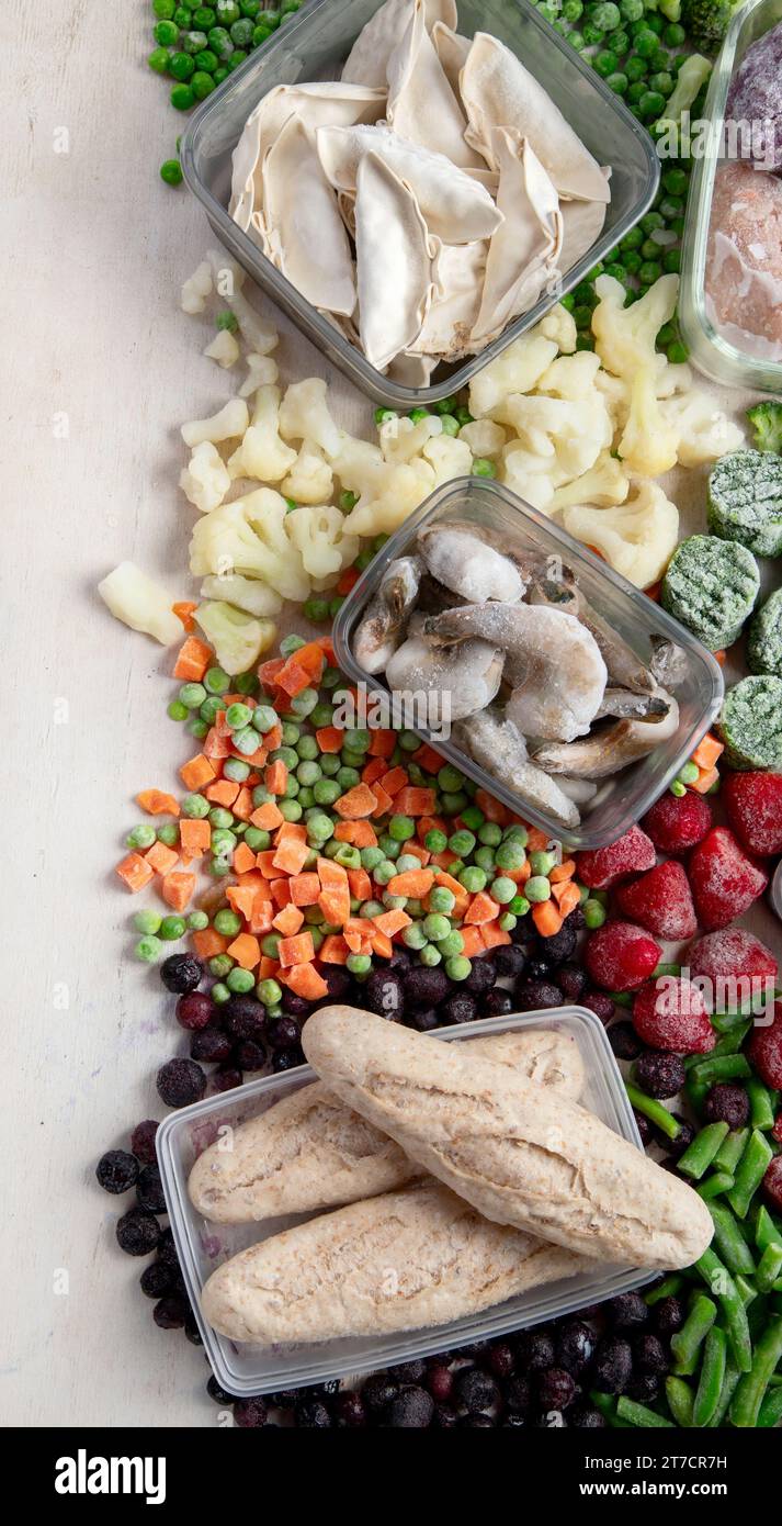 Frozen food, vegetables, fruits, meat, bread and fish on a white ...