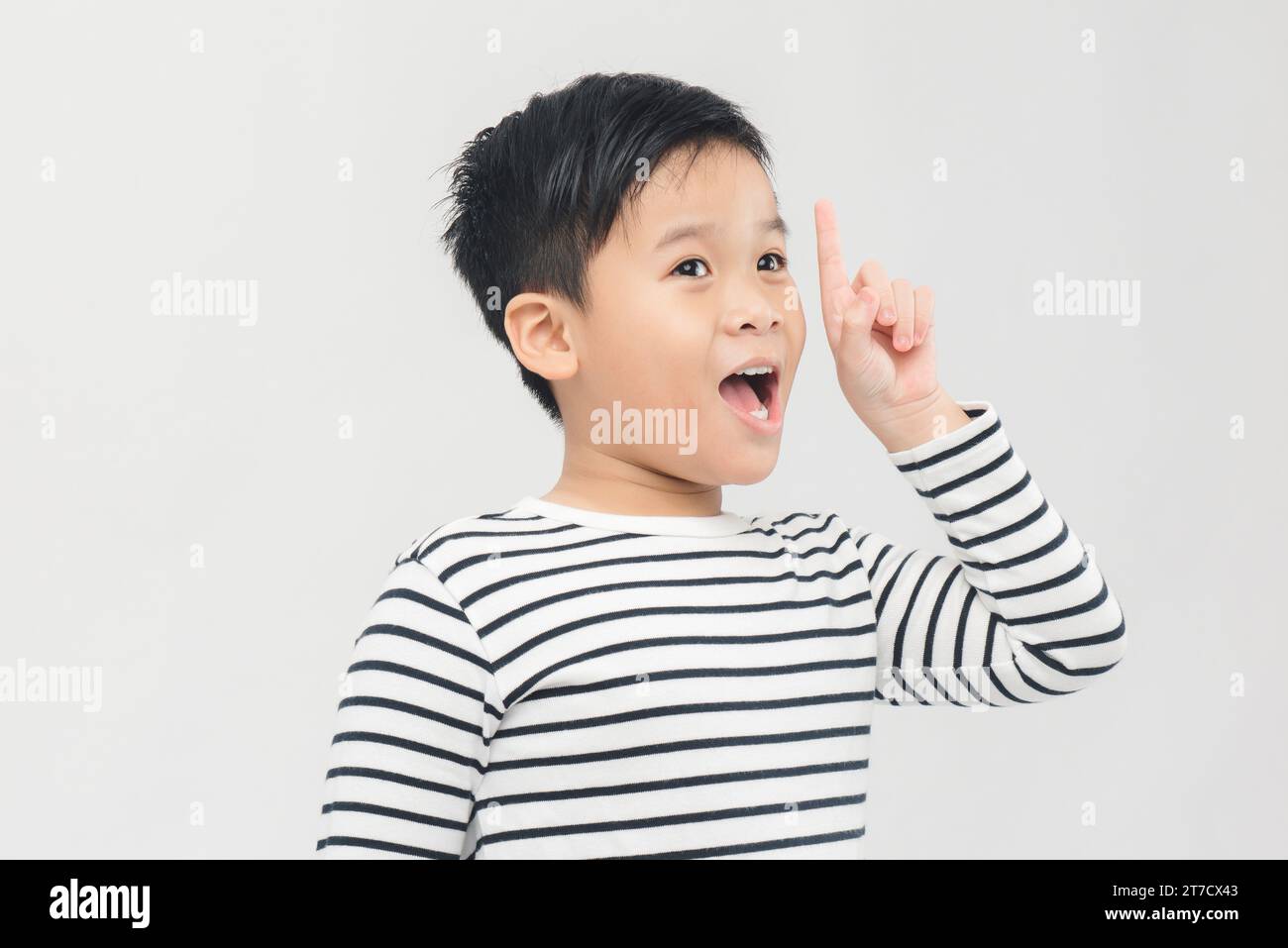 Little small smiling happy boy hold index finger up with great new idea ...