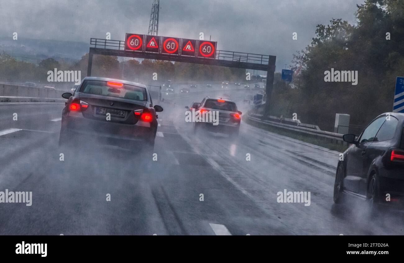 29 October 2023, Hesse, Ober-Mörlen: Cars driving at dusk in the rain ...