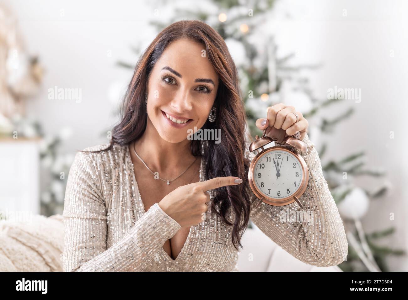 Woman pointing at the clock showing that Christmas is just around the ...