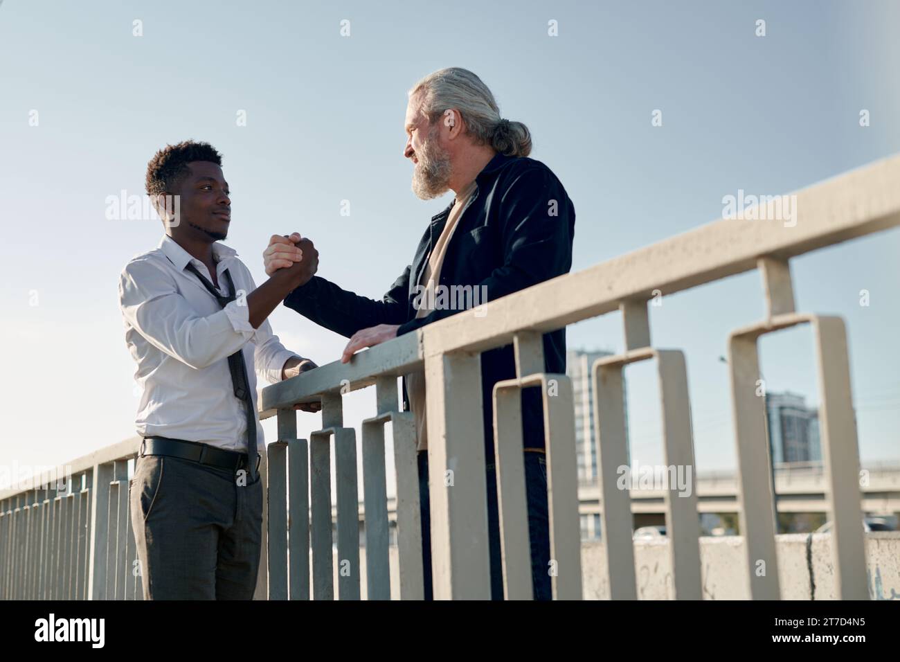 Mature man saving the guy from accident and giving him his hand to help ...
