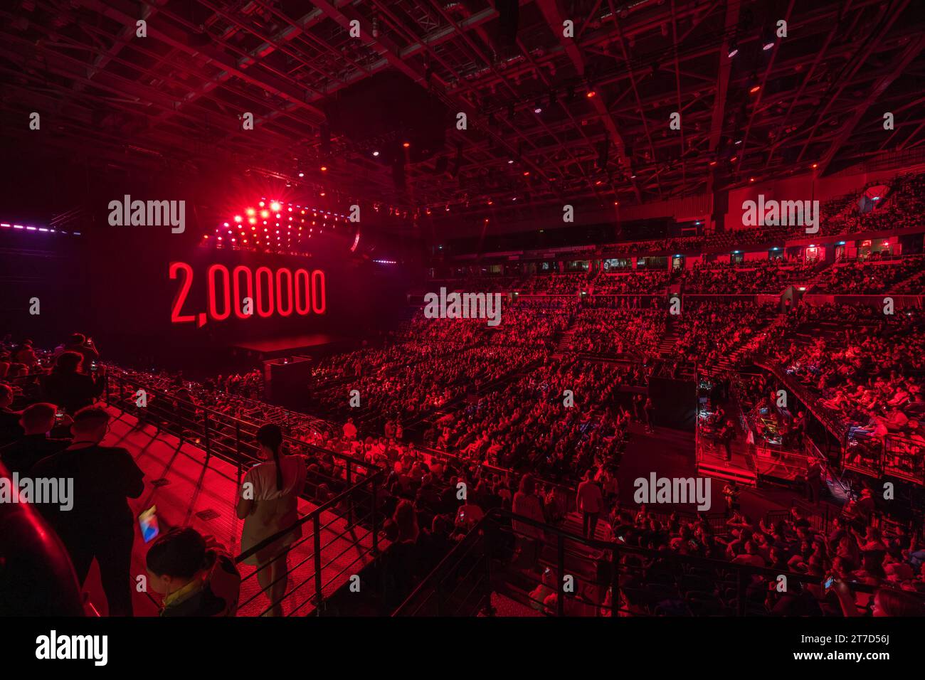 Aerial view of business crowd enjoying concert in large illuminated red ...