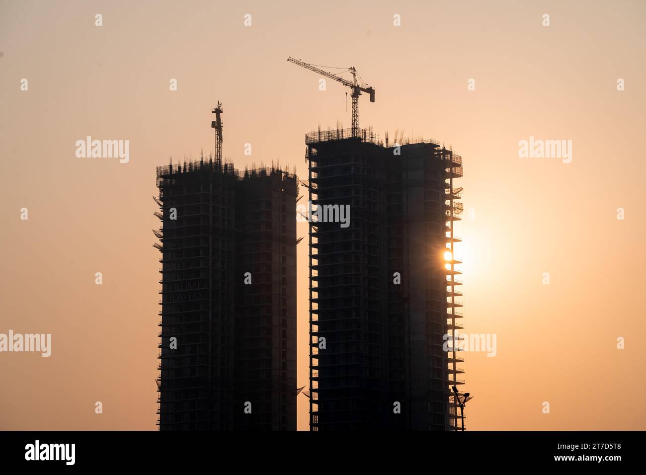 Silhouette of under construction building against sunset with crane on ...