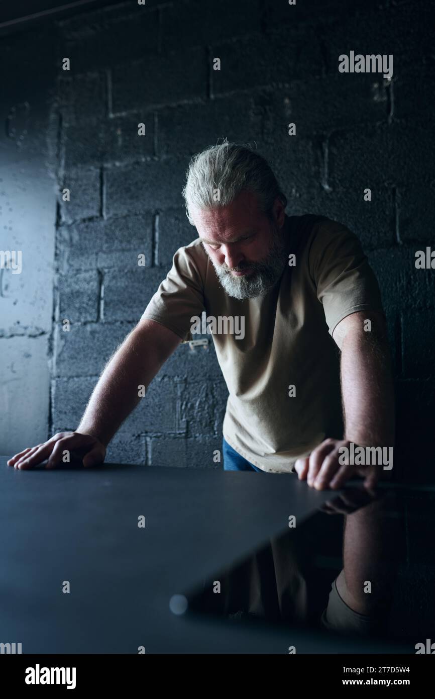 Vertical image of lonely man standing in dark room and contemplating ...