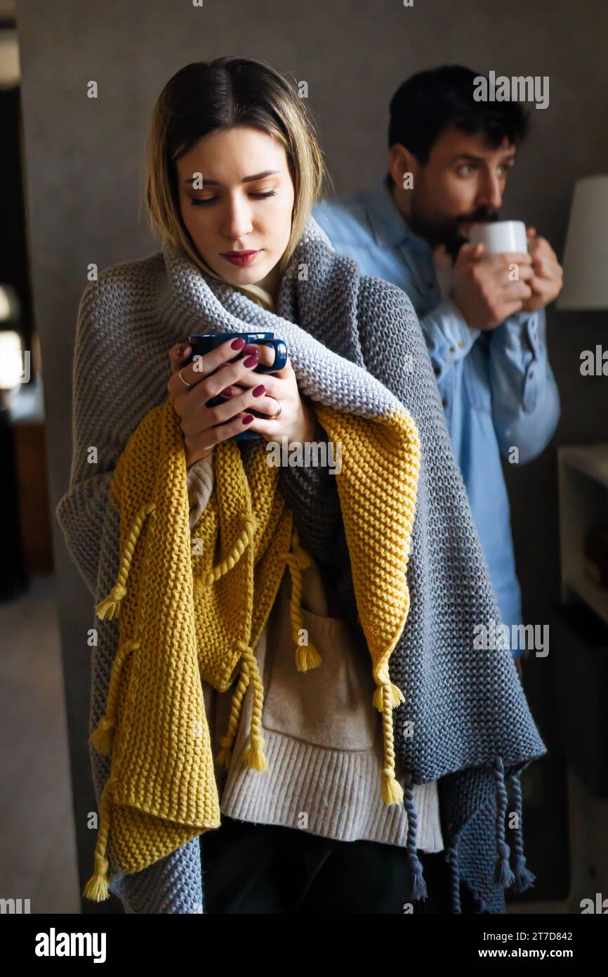 Freezing couple covered with a blanket. Man and a woman wrapped in a ...