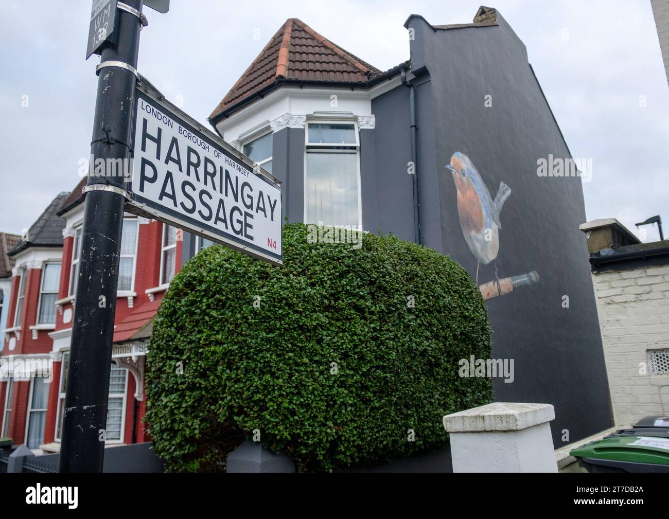 A street sign for Harrringay Passage, Haringey with a mural of a robin ...