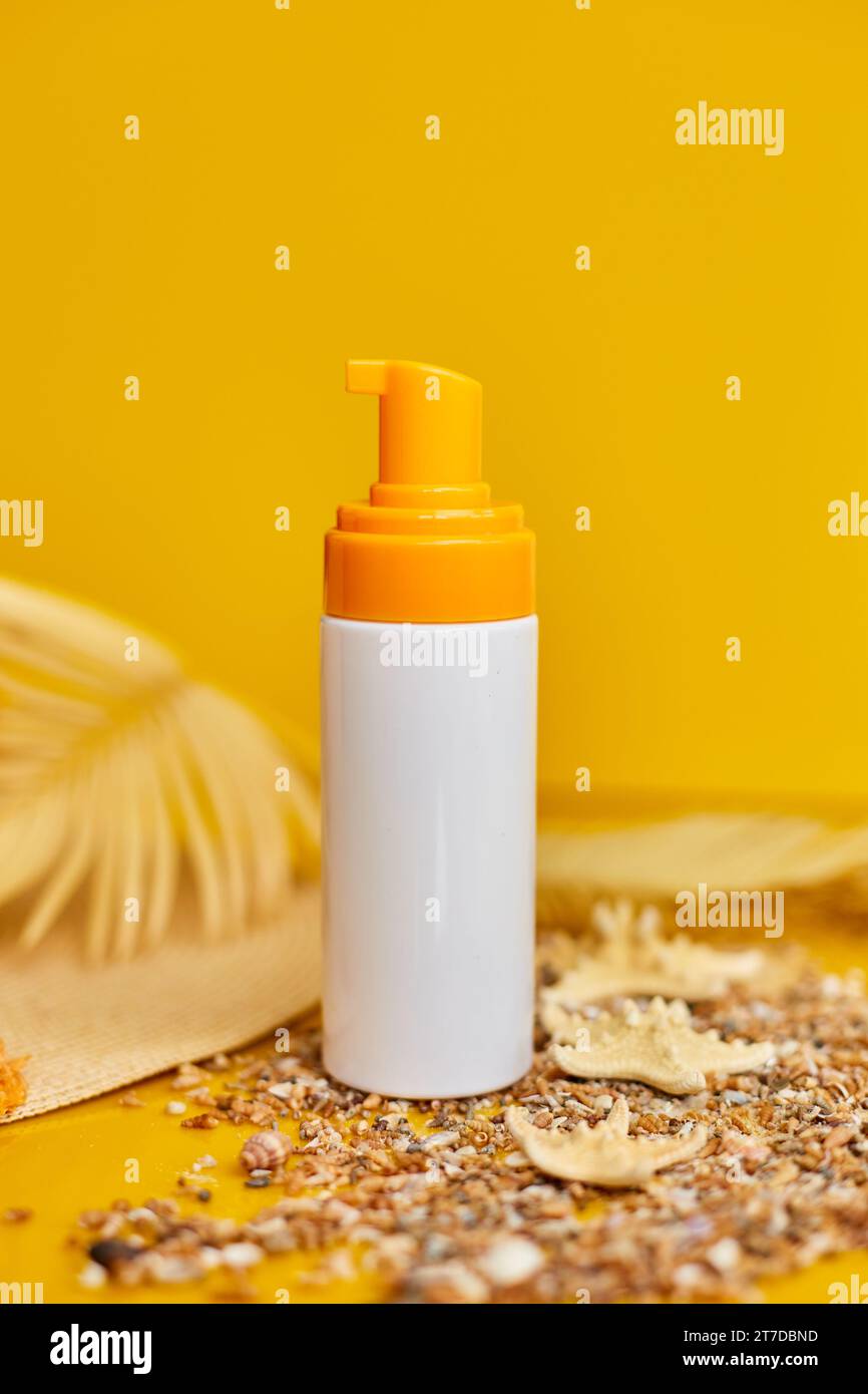Sunscreen tube mockup with shells, sand yellow background, summer ...