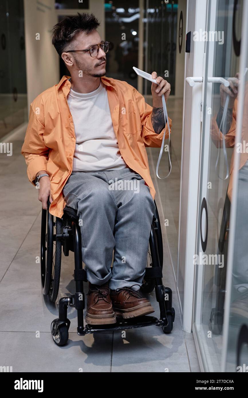 Vertical image of businessman with disability opening office door with ...