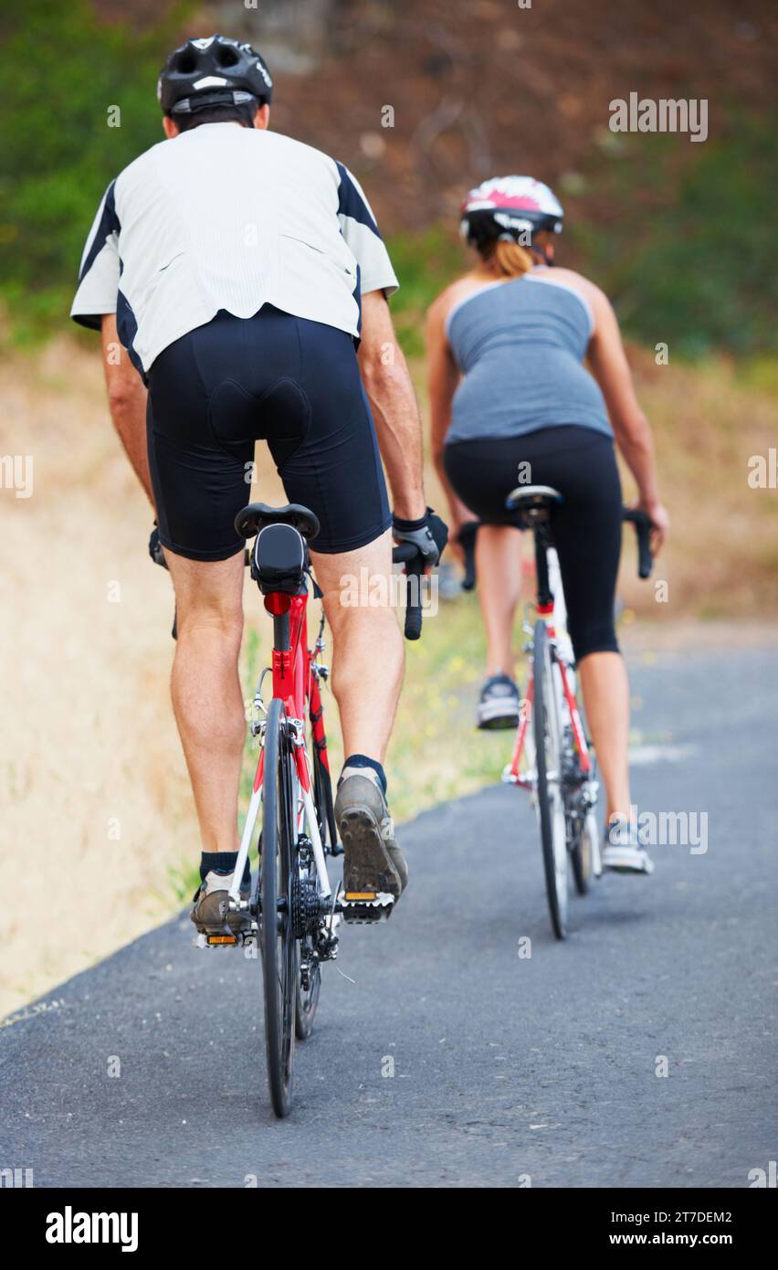 Back, road and couple cycling in nature for cardio, fitness and ...