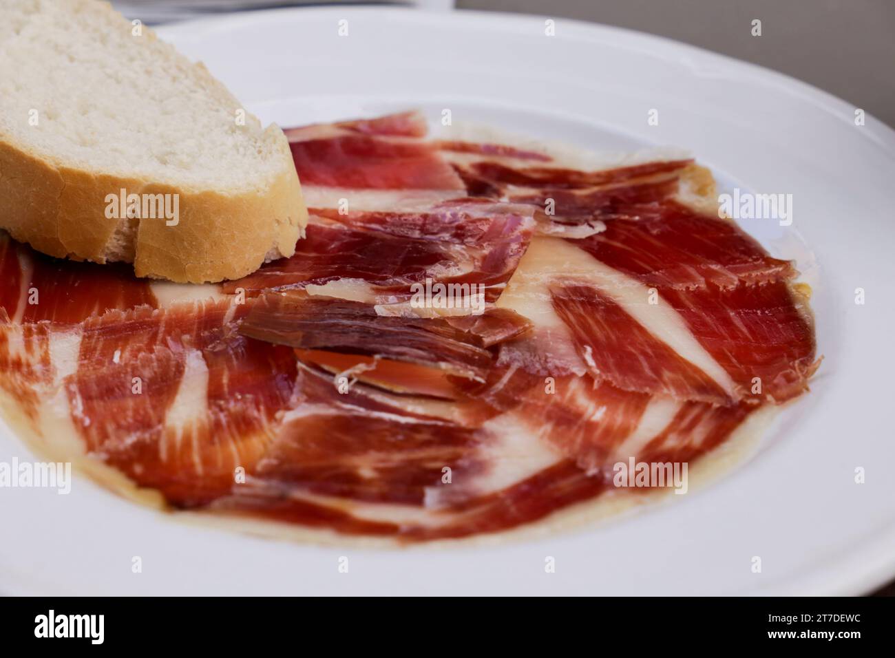 Tasty Iberico bellota ham plate with a slice of bread in a bar in Spain ...