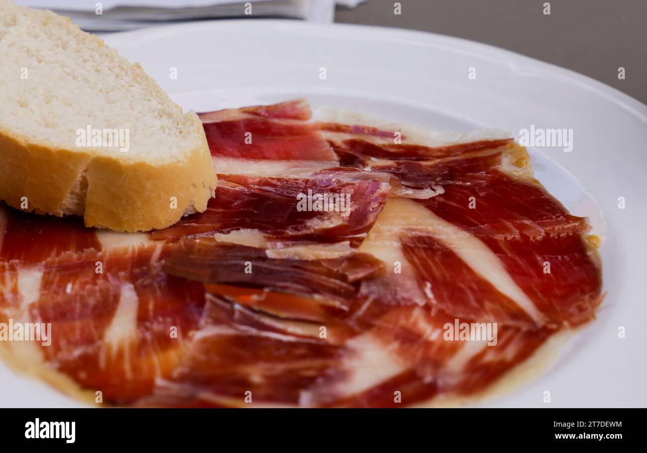 Tasty Iberico bellota ham plate with a slice of bread in a bar in Spain ...