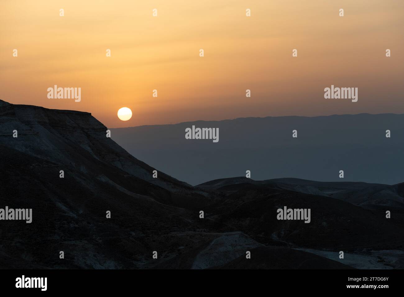 Sunrise from Israel's Judean desert looking east over the barren landscape toward the mountains ...