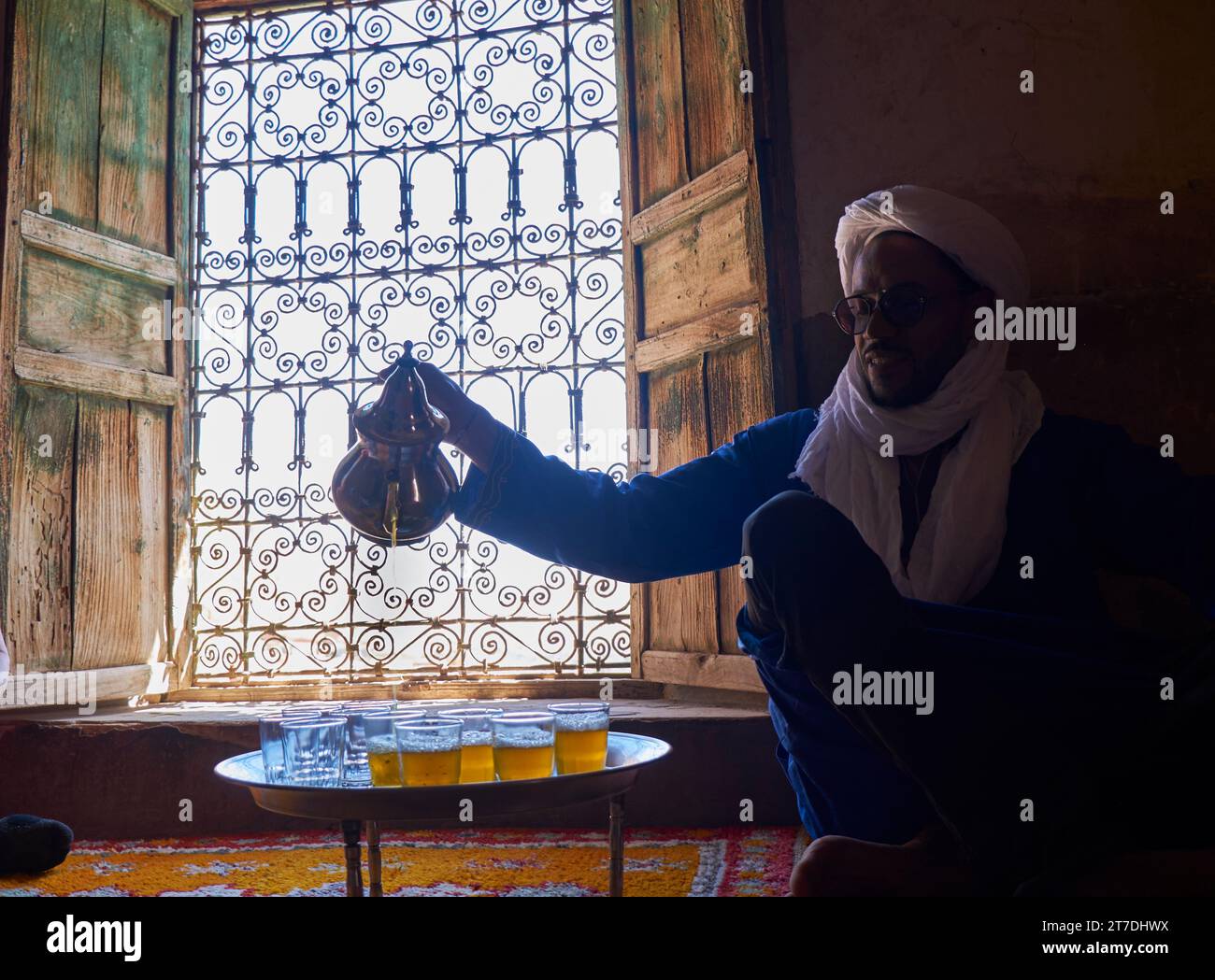 Tea hour with a Muslim in a traditional robe in the walls of an old ...