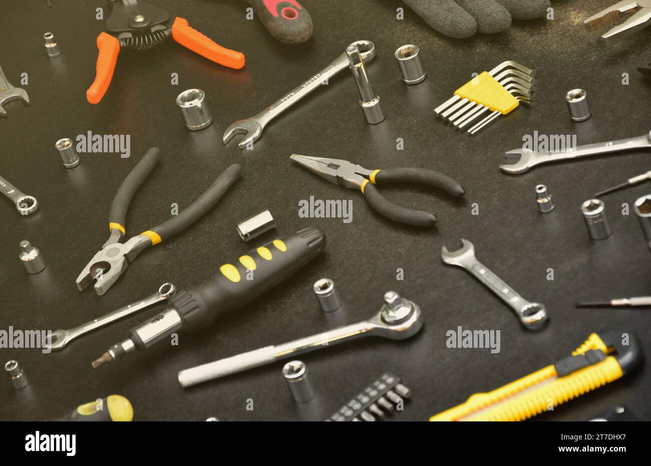 Handyman tool kit on black wooden table. Many wrenches and screwdrivers ...