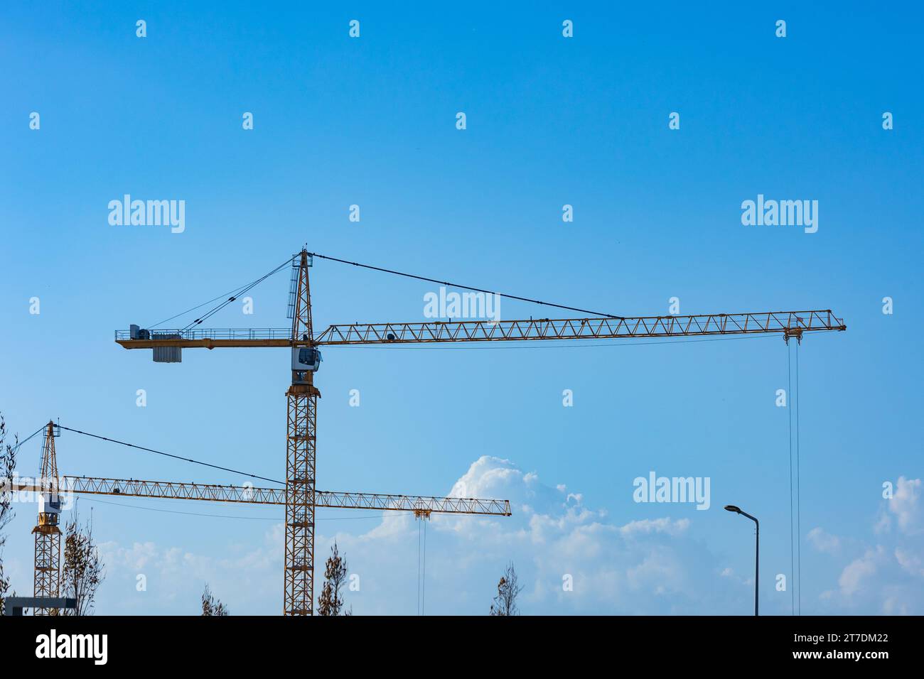Construction site or construction industry concept. Two tower cranes in ...