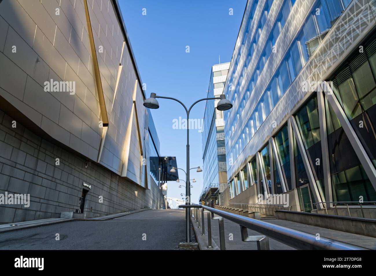 A modern street light illuminating a city street corner surrounded by ...