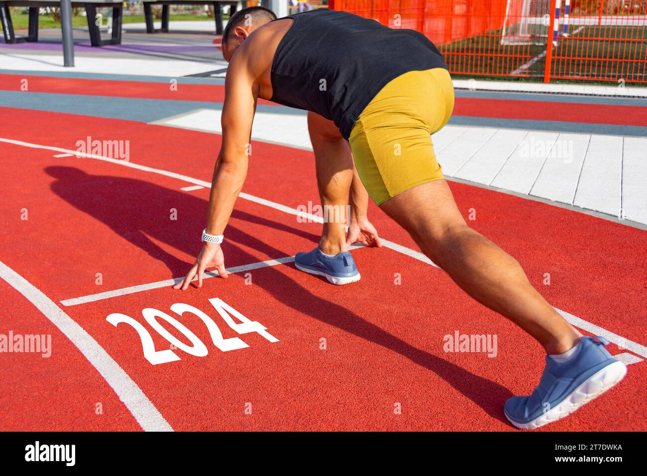 Athlete runner in a pose ready to start on a red treadmill line with ...