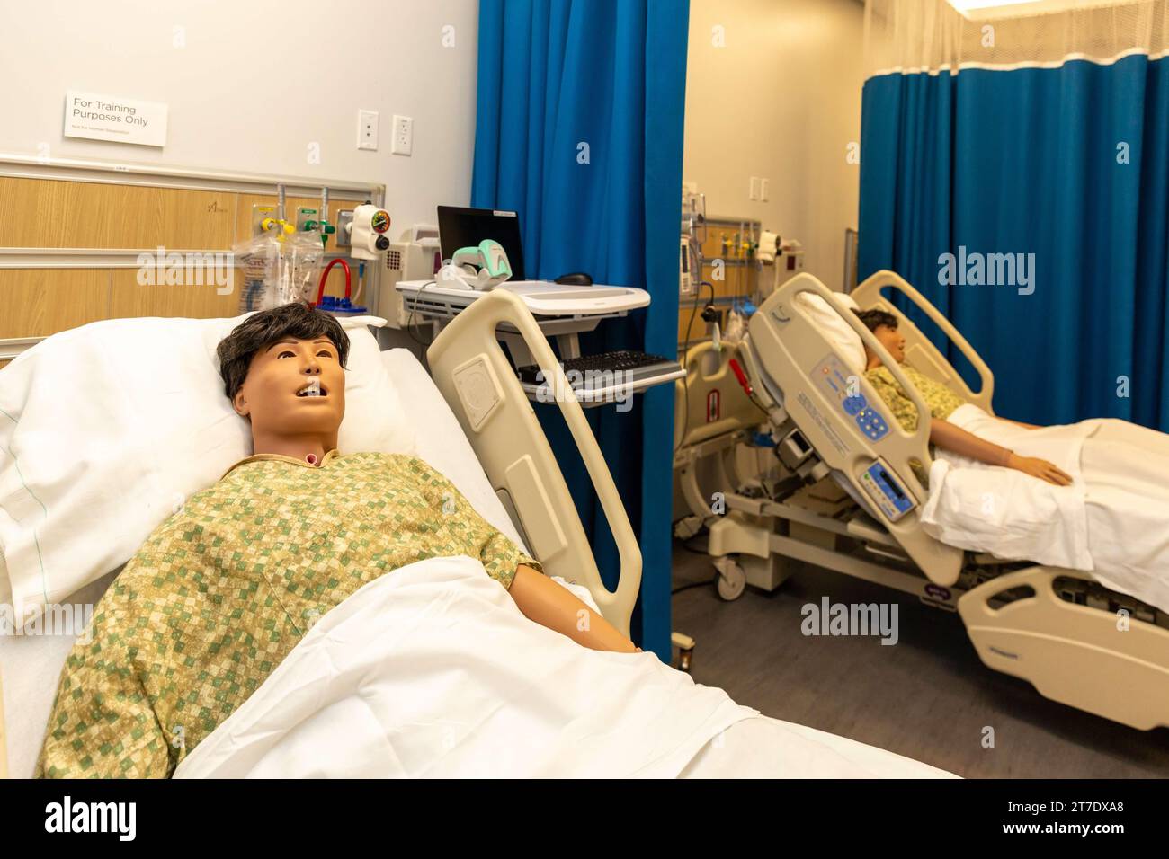 A medical mannequin in a hospital bed, with the covers pulled up to its ...