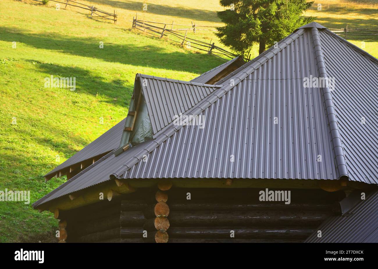 The roof is made of gray embossed metal sheets. Wooden house in the ...