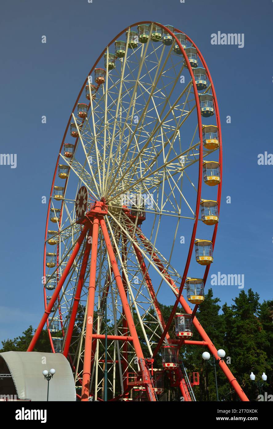 Big and modern multicolour ferris wheel on clean blue sky background ...