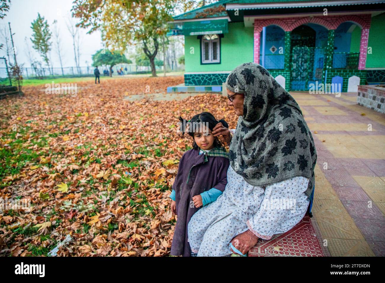 Srinagar, India. 13th Nov, 2023. A woman with her child sit outside a ...