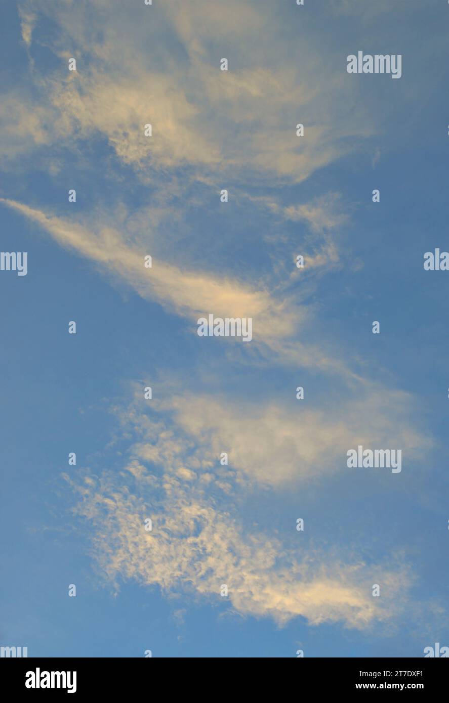 A blue cloudy sky with many small clouds blocking the sun Stock Photo ...