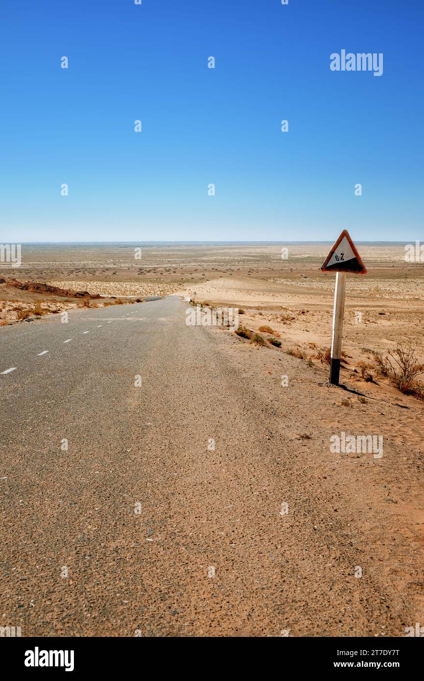 A traffic sign on a country road through a desert landscape, Kysylkum ...