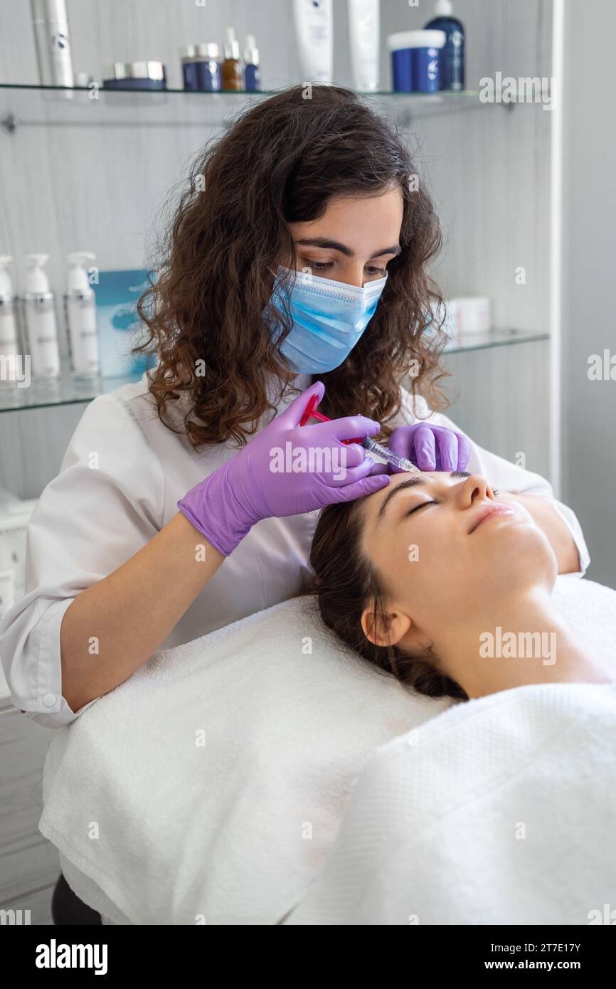 Cosmetologist doctor doing facial rejuvenation injection to woman ...
