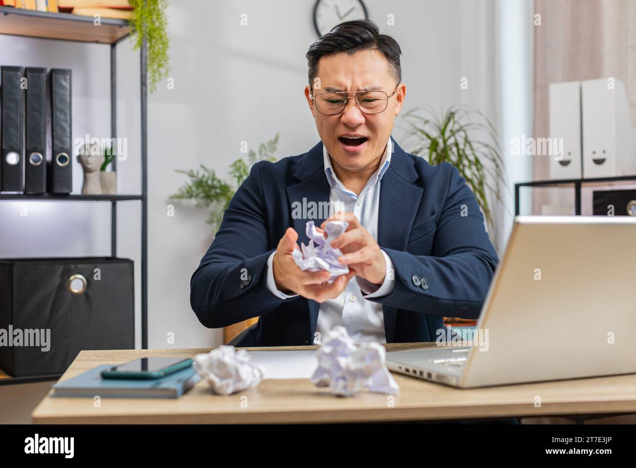 Angry furious Asian businessman working at office throwing crumpled ...