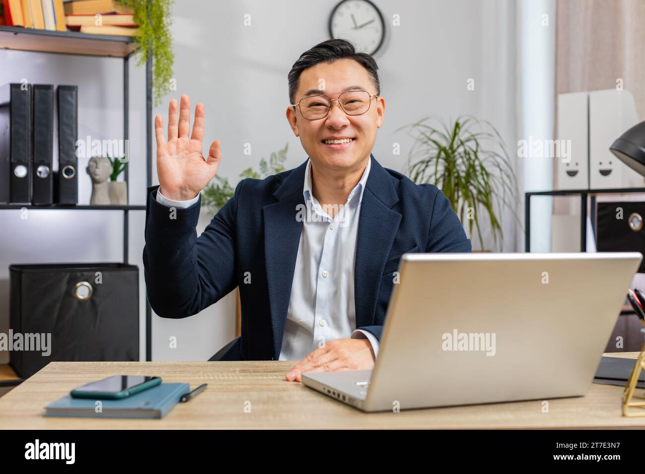Hello. Asian business man working on laptop computer smiling friendly ...