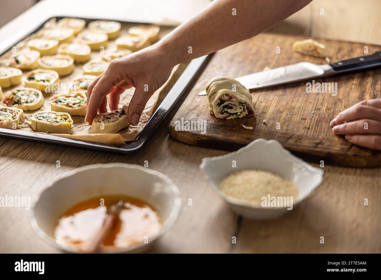 The cook places raw mini puff pastry cookies on a baking sheet. Recipe ...