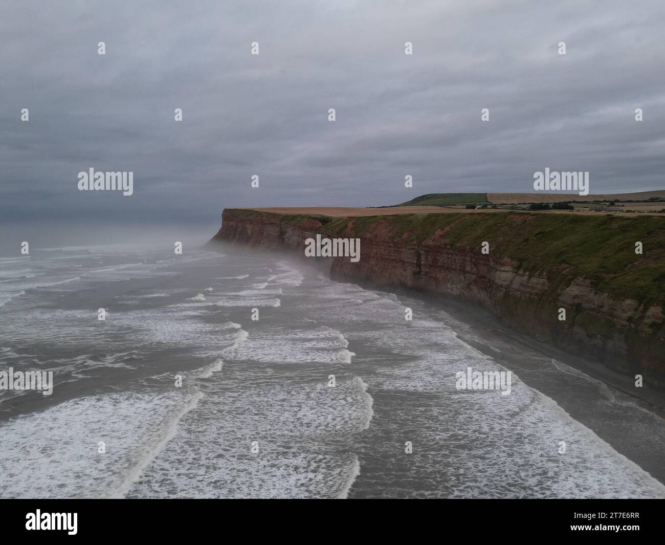This image features an expansive, empty ocean on a stormy and foggy day ...