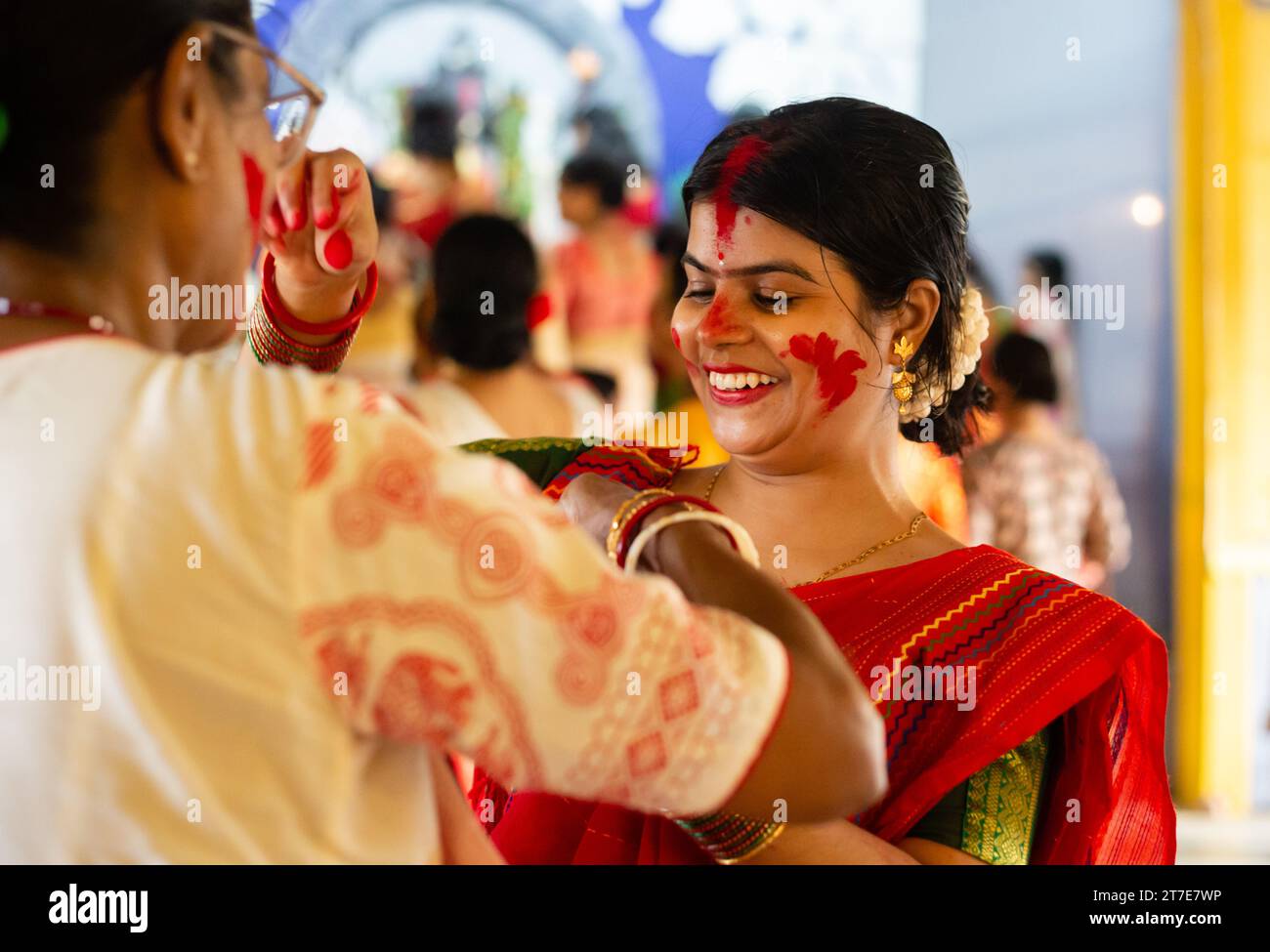 A beautiful woman in traditional dress with red colored smiling face ...