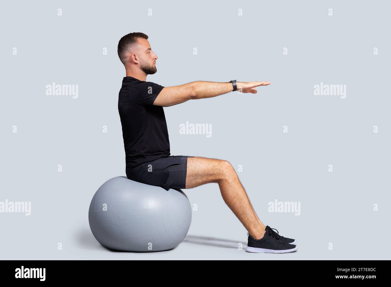 Focused muscular millennial caucasian man with beard, make exercises on ...