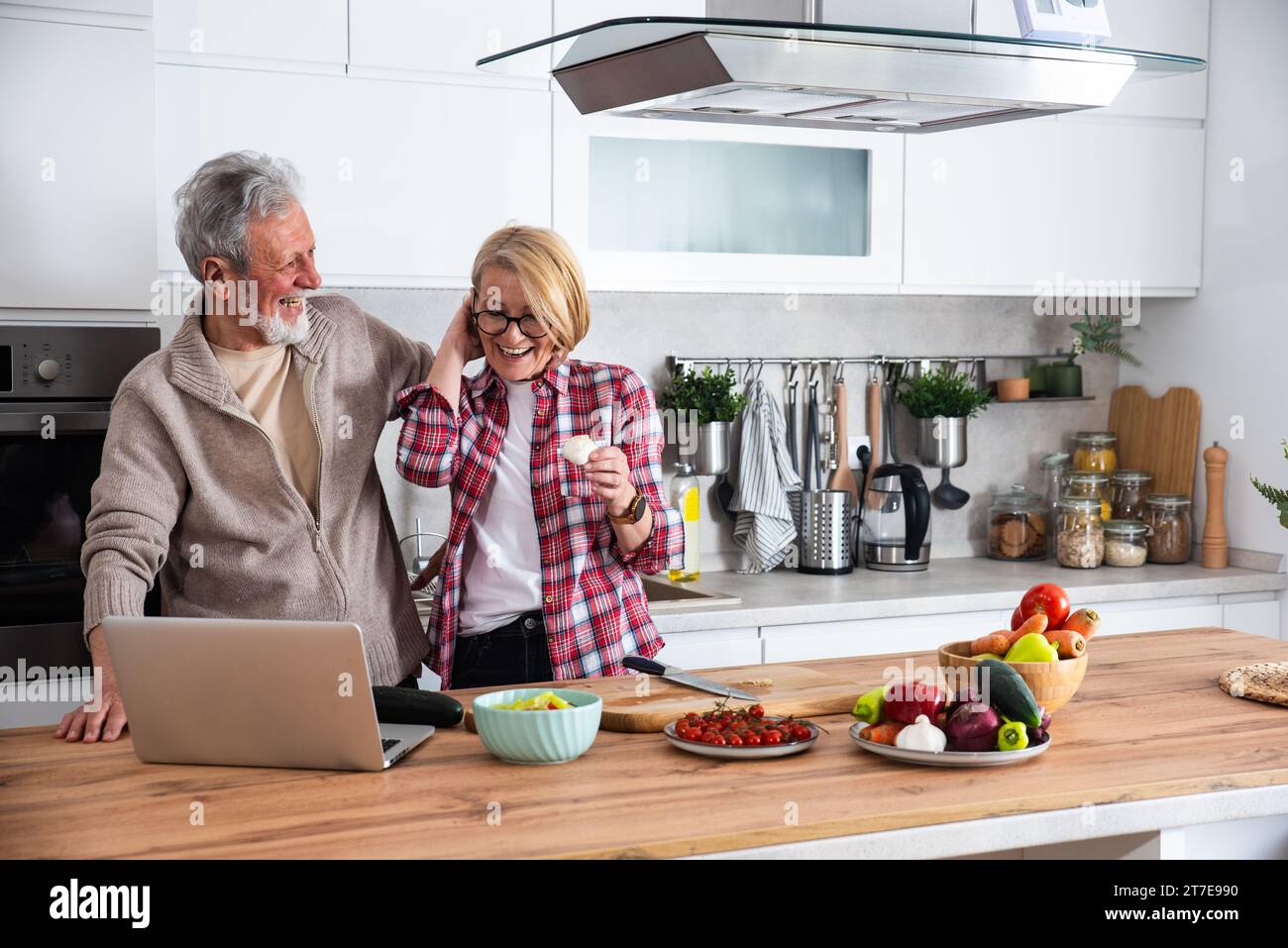 Senior couple cooking dinner together in the kitchen for golden wedding ...