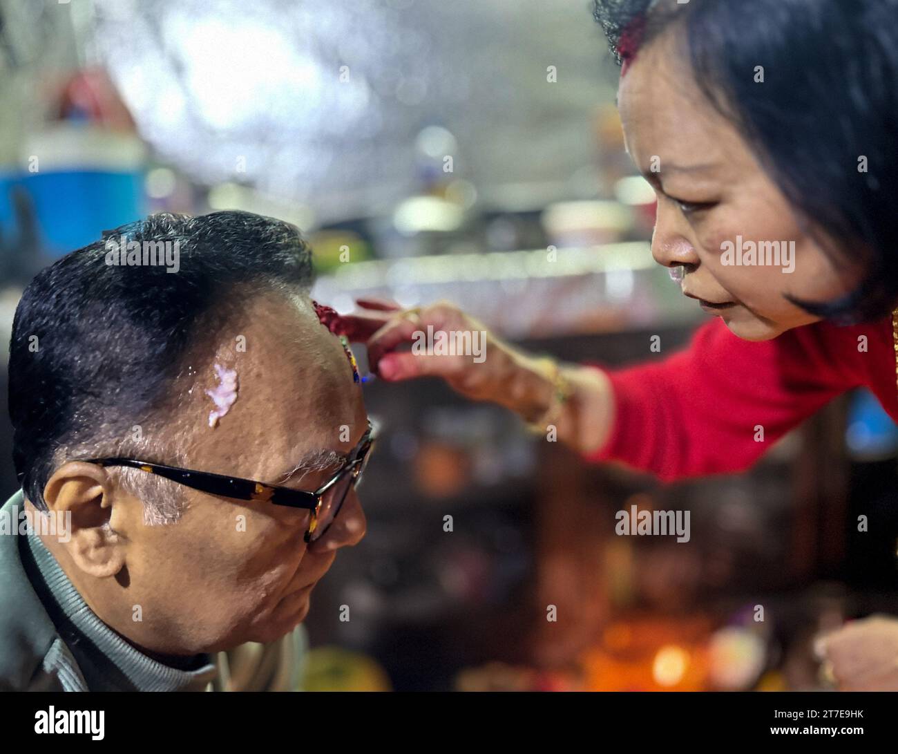 Kathmandu, Bagmati, Nepal. 15th Nov, 2023. A woman offers colorful tika ...