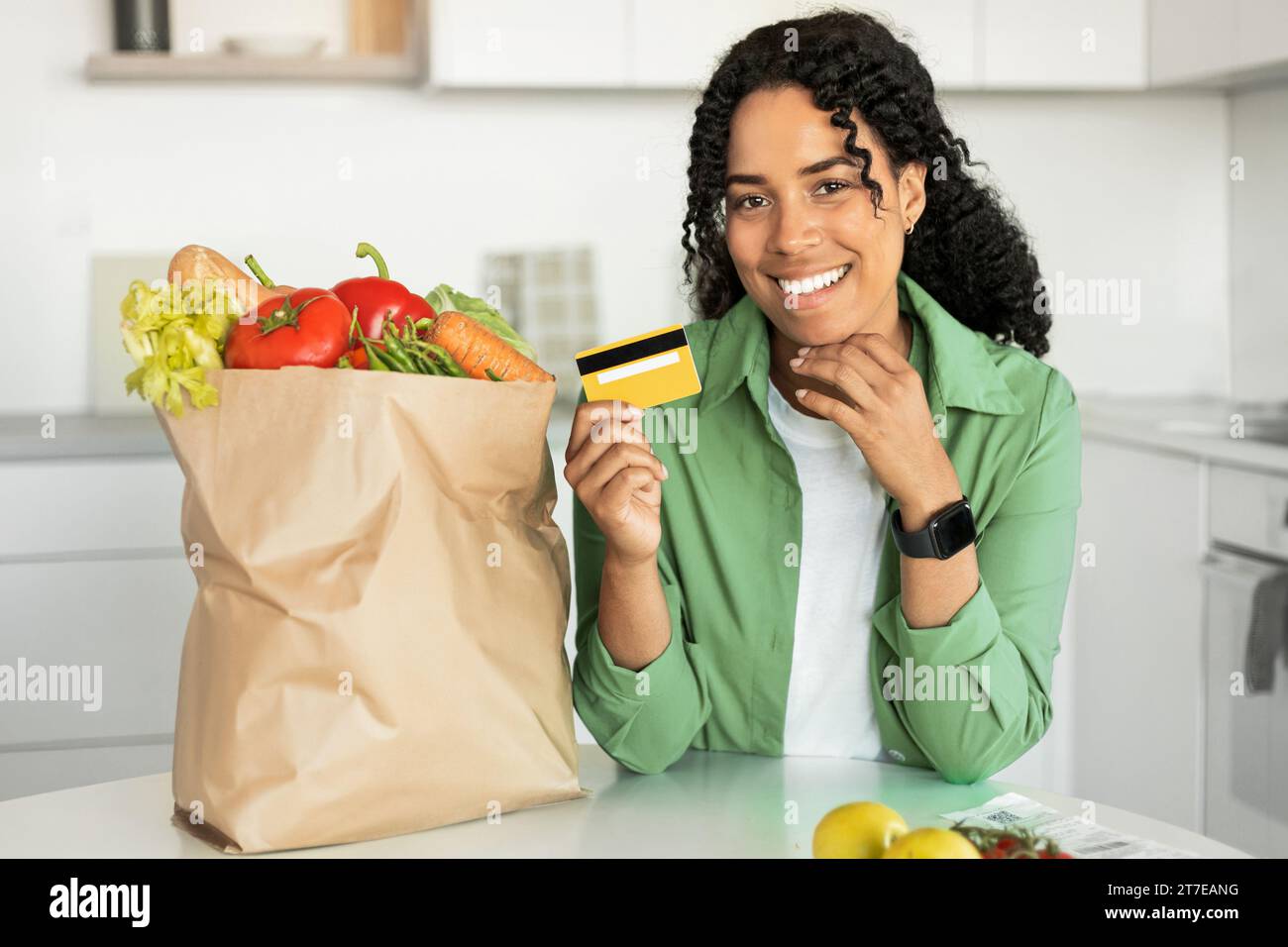 Black woman showcases credit card for grocery shopping in kitchen Stock ...