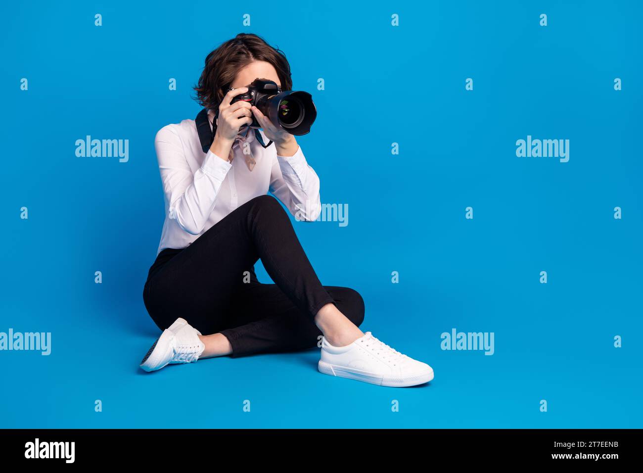 Full length profile photo of young person sit hands hold camera making ...