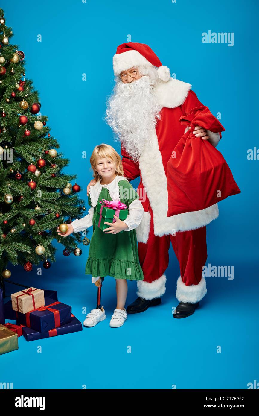 Santa Claus holding sack bag near cheerful girl with prosthetic leg ...