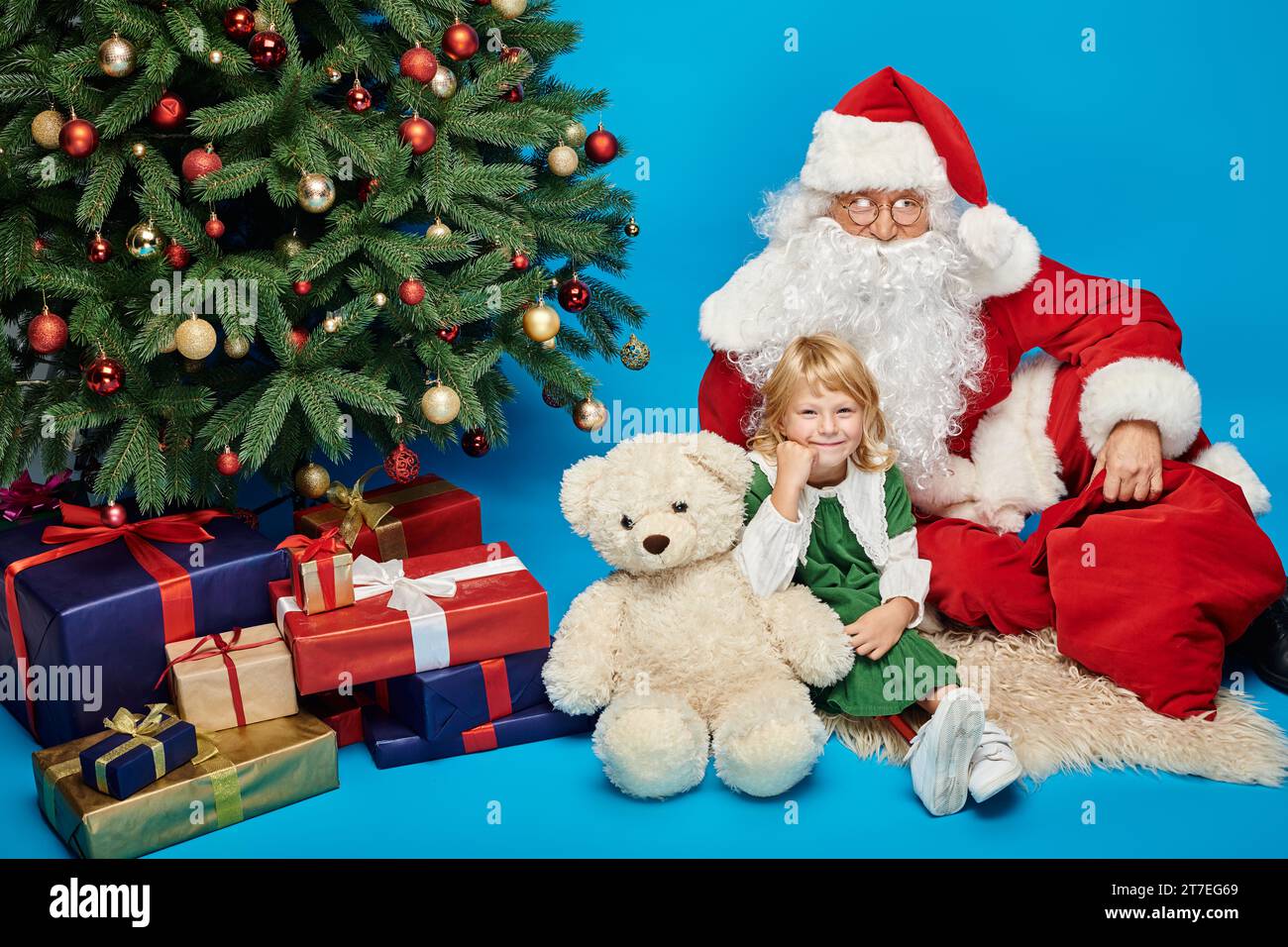 happy child with prosthetic leg and teddy bear sitting with Santa Claus ...
