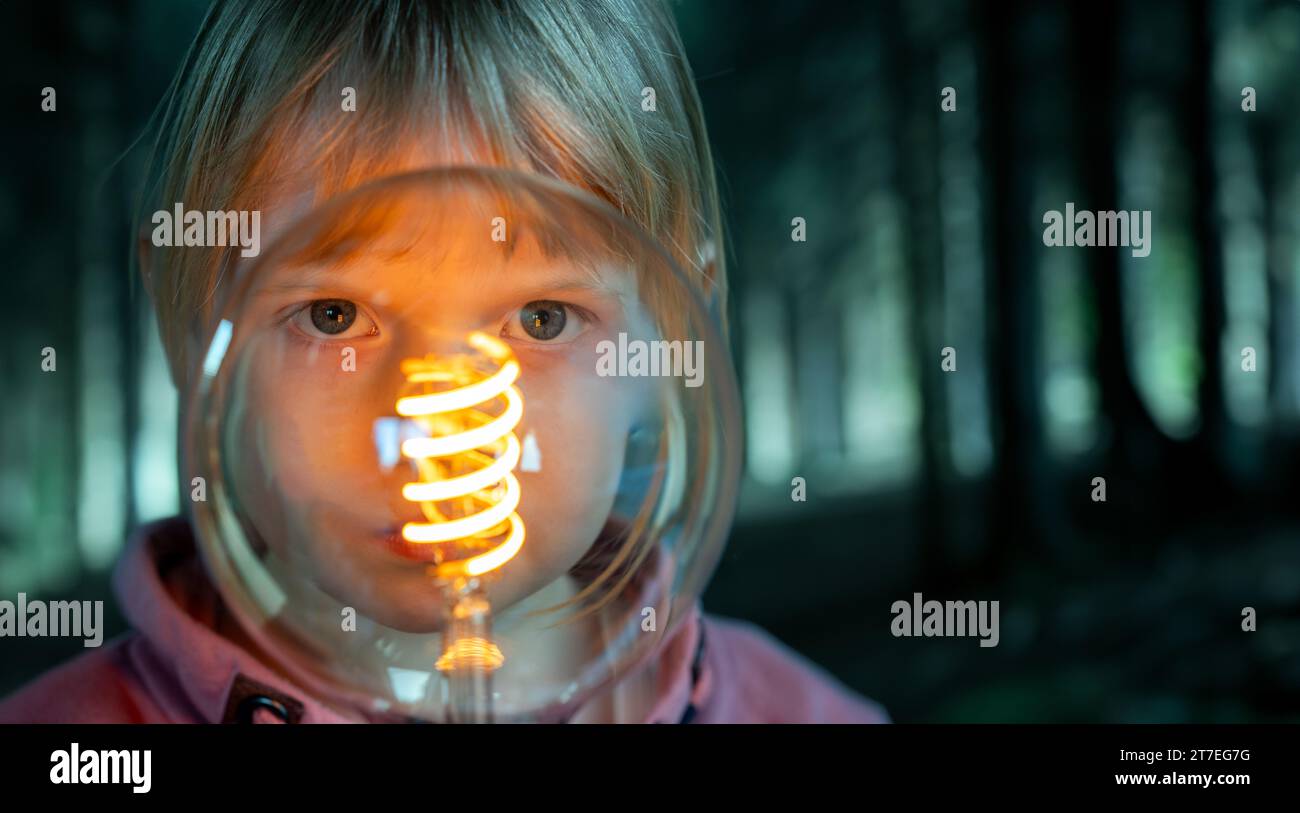 Young child looks curiously into a filament light bulb Stock Photo - Alamy