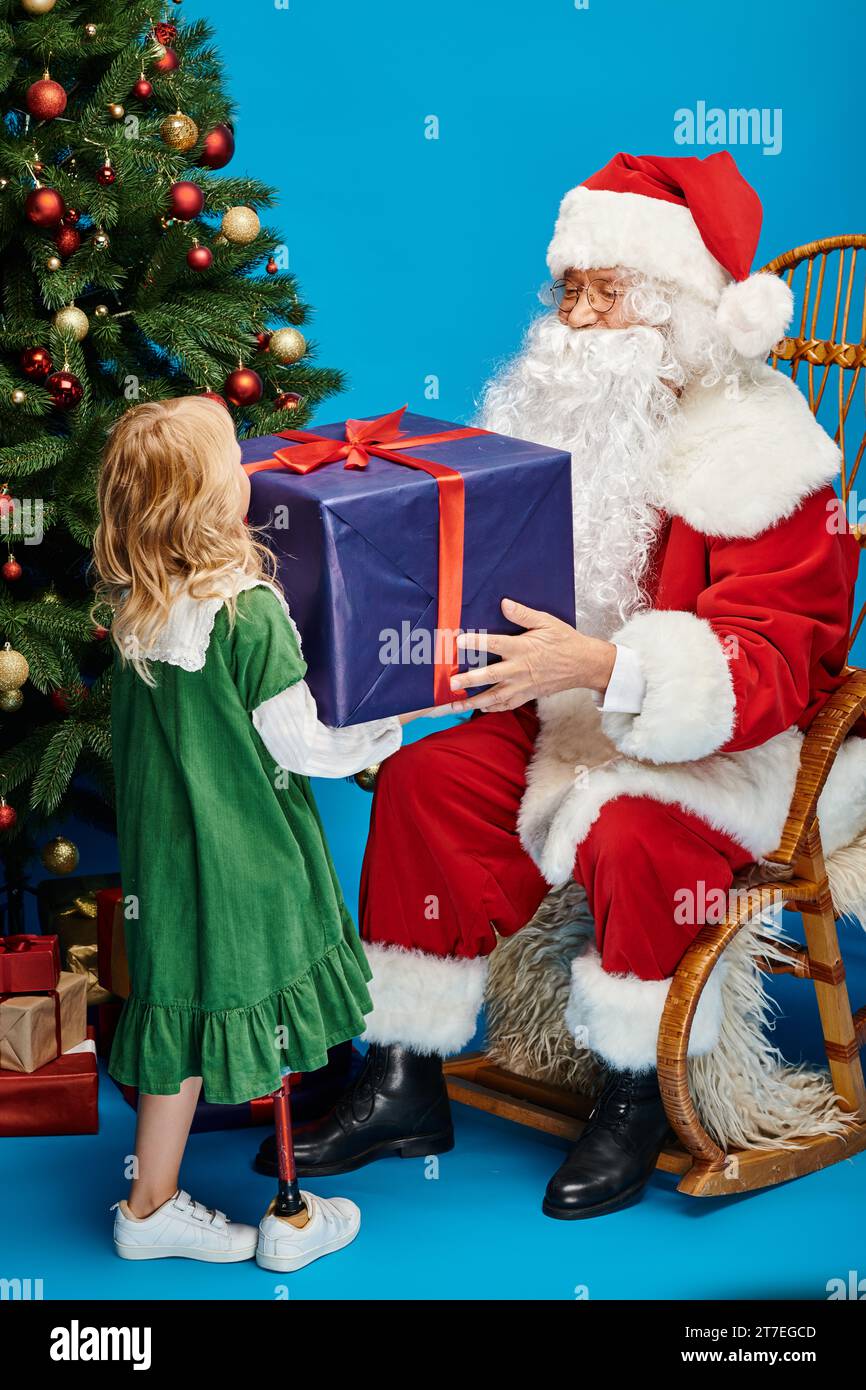Santa Claus giving present to happy girl with prosthetic leg next to ...