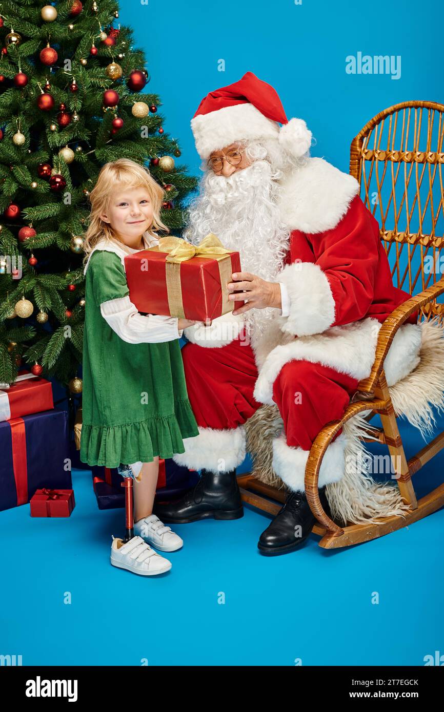 Santa giving present to happy girl with prosthetic leg next to ...