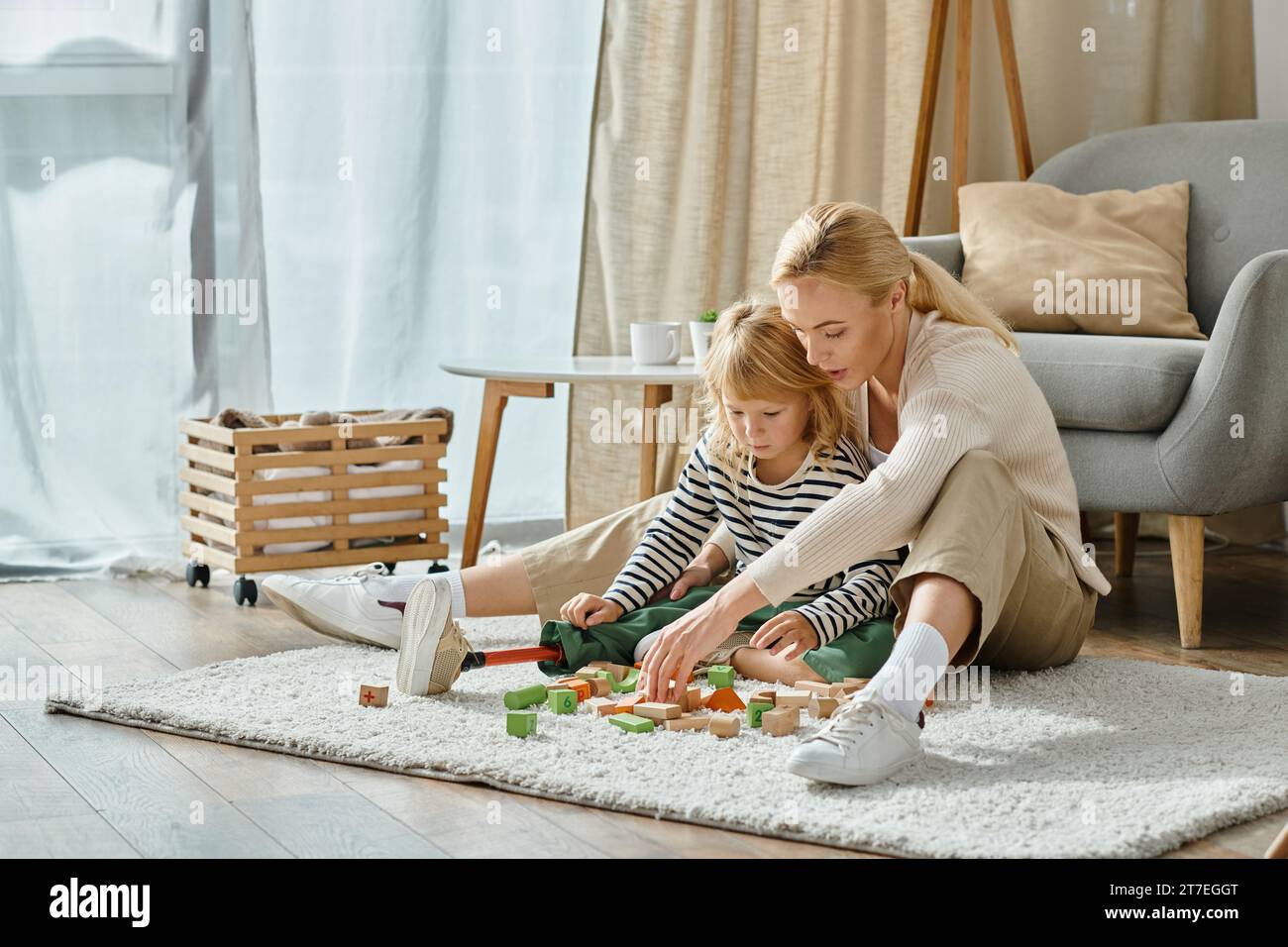 blonde girl with prosthetic leg sitting on carpet and playing wooden ...