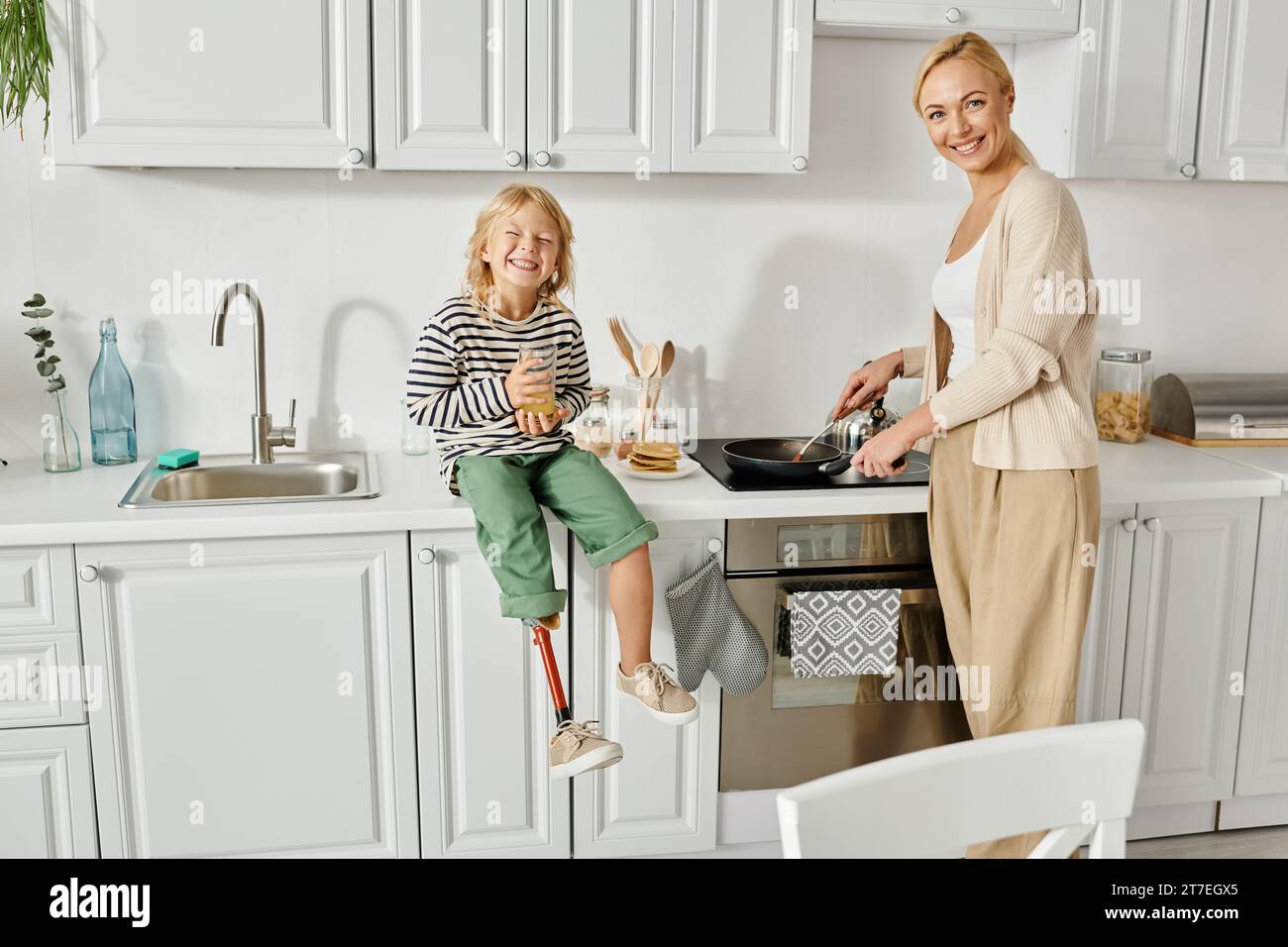 happy girl with prosthetic leg sitting on countertop with orange juice ...