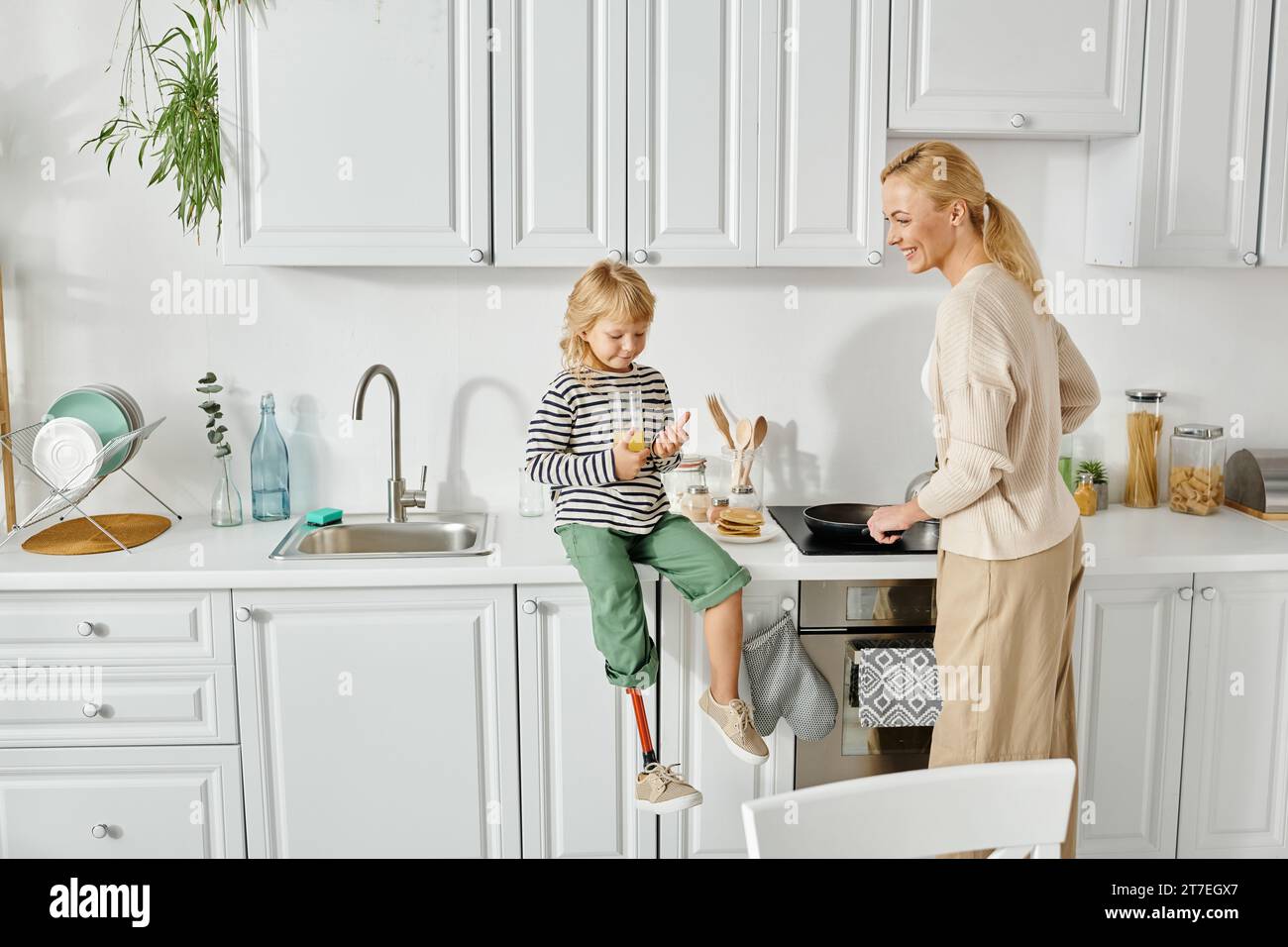 happy girl with prosthetic leg sitting on countertop with orange juice ...