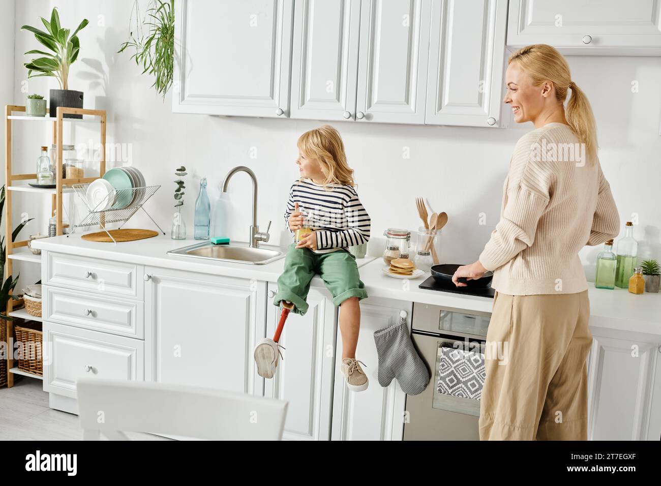 happy girl with prosthetic leg sitting on countertop with orange juice ...